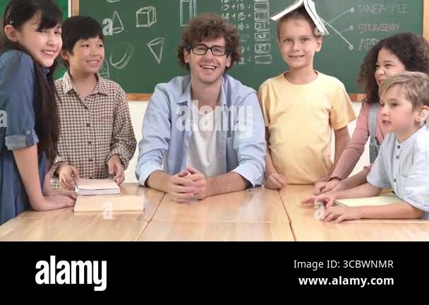 Professional caucasian teacher and diverse student looking at camera while happy boy giving ...