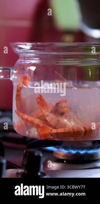boil shrimp Cooking at home. Closeup view of a woman hand stirring a ...