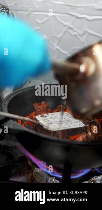 Professional chef pouring hot water from metal pot onto meat, carrots ...