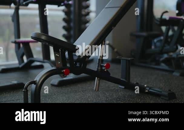 Adjustable weight bench in modern gym with red knobs close up. Empty ...