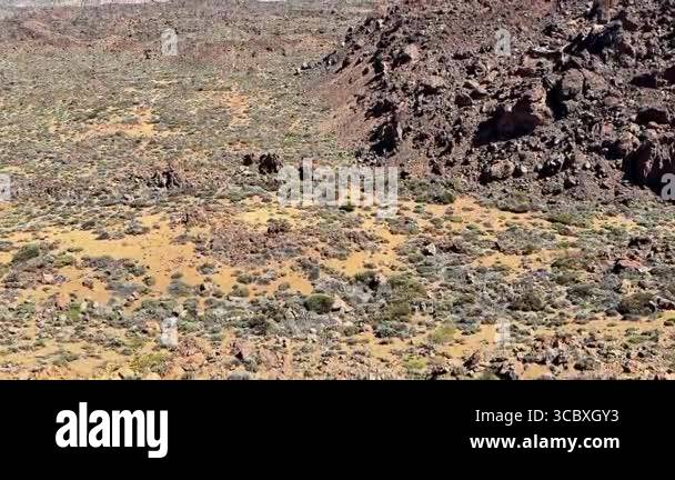 A breathtaking view of a rocky desert terrain showcasing sparse vegetation and mountainous ...