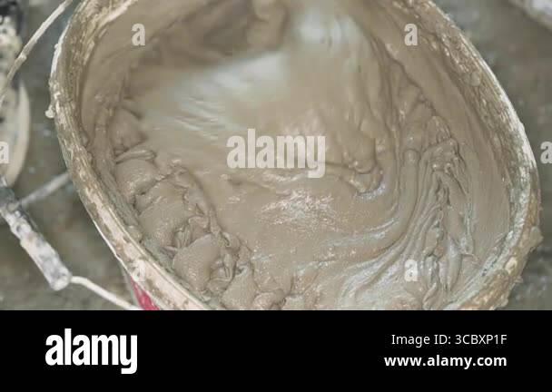 Wet mortar cement paste, mixed in bucket at house construction site ...