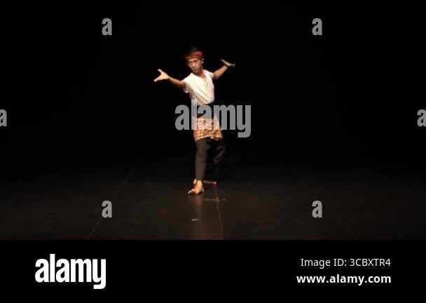 A dancer performing on stage, wearing traditional attire with a modern ...