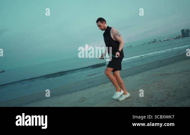 Athlete jumping rope on beach, showcasing energy and fitness dedication ...