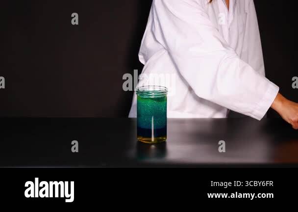 A scientist in a lab coat conducts a dry ice experiment, showcasing ...