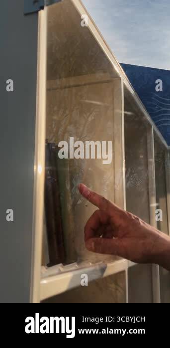 Individual observes and points at dust accumulation on glass surface in ...