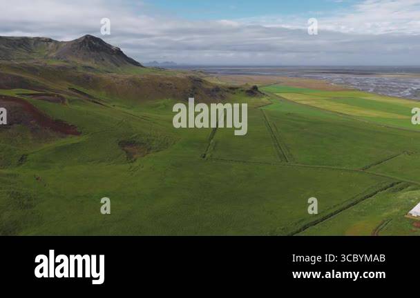 Aerial view of a rural Icelandic farmstead with green fields, a white ...