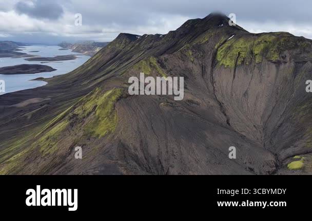 Aerial view of Iceland's volcanic terrain with mossy slopes, winding ...