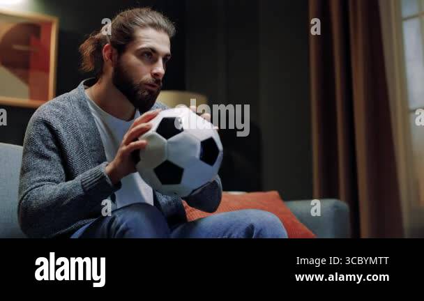 Male relaxing at home. Happy man raising hands while watching football ...