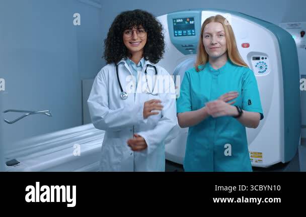 Two MRI specialists posing with arms crossed. Doctor in white gown and ...