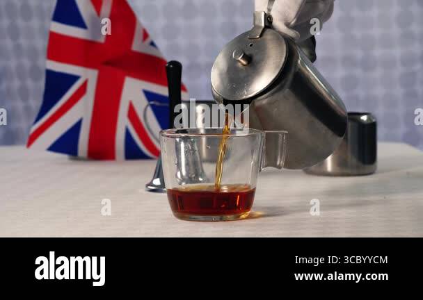 Waiter pouring traditional English tea from teapot close up zoom shot ...