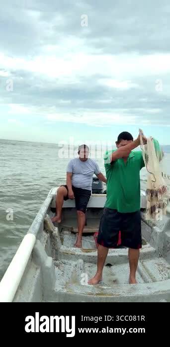 Fishermen casting fishing net from small boat in ocean Stock Video ...