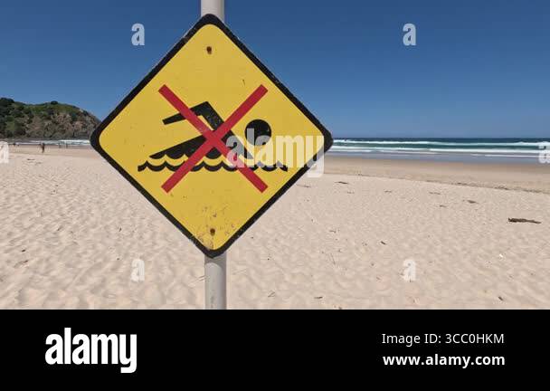 Yellow sign warning against swimming due to danger Stock Video Footage ...