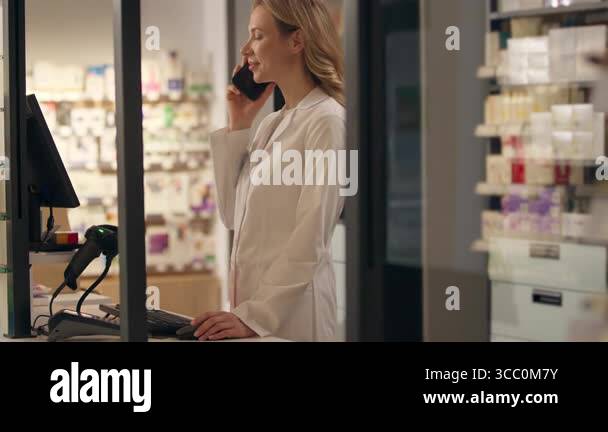 Pharmacy drugstore Caucasian pharmacist woman talking mobile phone ...