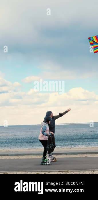 Flying kite. roller skating outdoors. Father and teenage daughter are ...