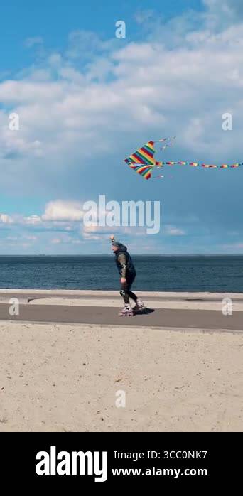 Flying kite. roller skating outdoors. Carefree man is flying a kite ...