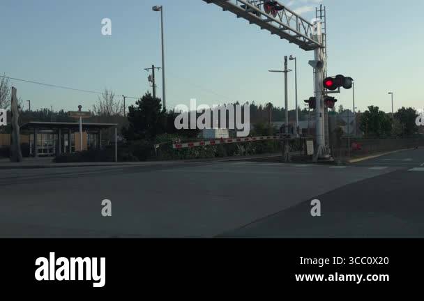 Railroad crossing barrier lowered with red signal lights flashing ...