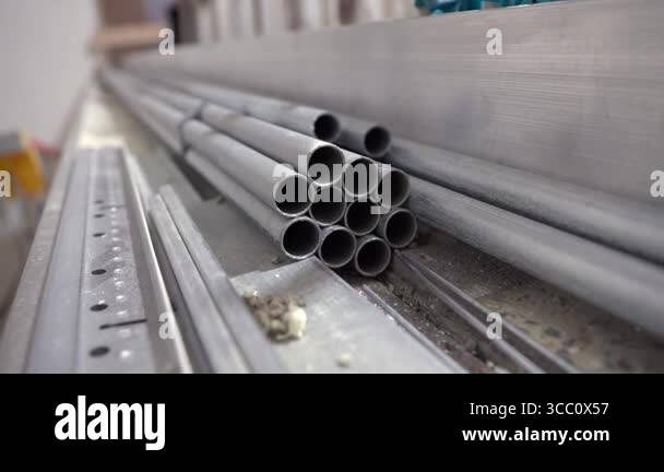 Close-up of aluminum pipes neatly stacked indoors. Captured in a ...