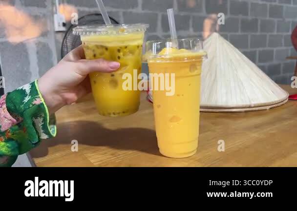 glass with mango juice, bamboo straw, half of fresh mango, yellow ...