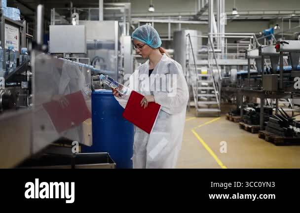 Female quality control inspector wearing protective clothing and mask ...