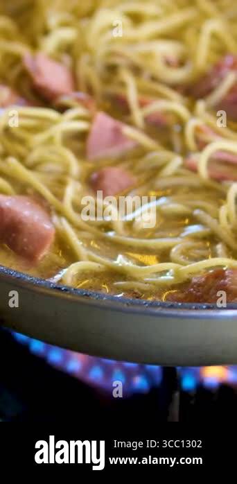 Close-up of spaghetti pasta In boiling hot water in steel pan ...
