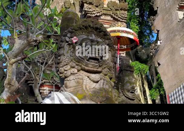 Traditional Balinese stone guardian statues at Hindu temple entrance in ...