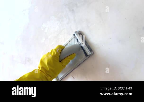 Worker sands drywall with sandpaper, preparing wall for painting Stock ...