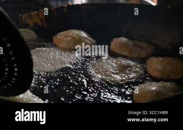 Puri orpoori frying big iron pan. It a type ofdeep friedbread, made ...