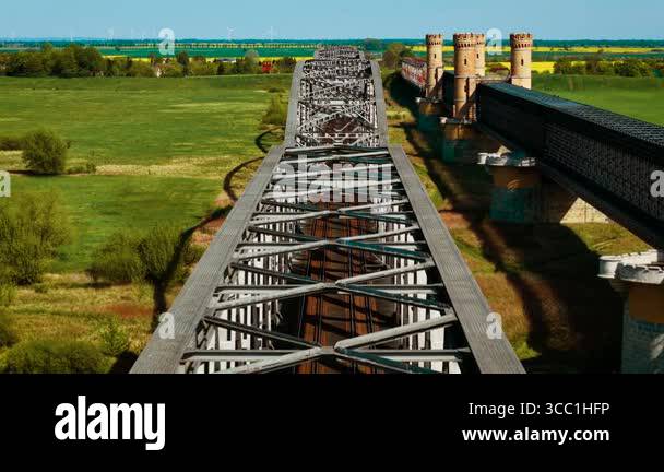 Railway bridge crossing wide green field. Structure spanning ...