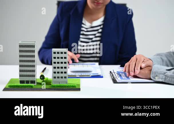 Client and broker agent have a successful deal sitting at the desk with ...