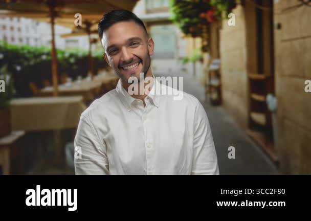 Young man smiling playfully outdoors in urban street setting with ...
