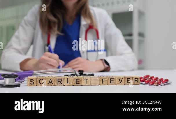 Doctor takes notes at desk with Scarlet Fever on wooden blocks near red ...
