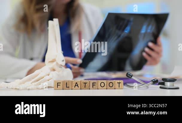 Word Flatfoot written on wooden blocks focusing on foot condition. Lab ...