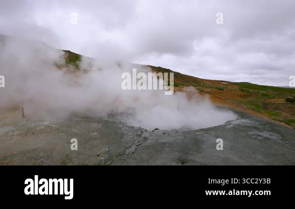 White steam rises from boiling mud pots and bubbling gray mud emerges ...