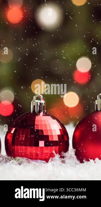 Animation of four red christmas baubles decoration with snow falling ...