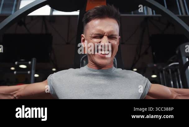 Close up face sporty man is exercising in gym fitness body strength ...