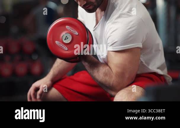 Portrait man doing exercises with a dumbbell in gym fitness body ...