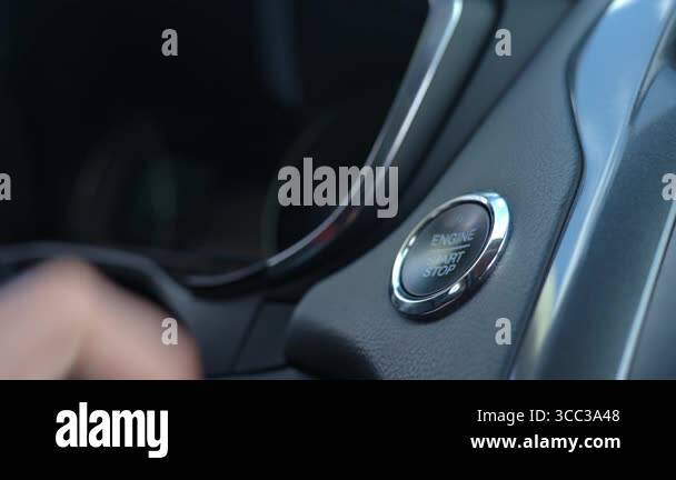 Close-up of hand pressing start button to turn on car engine. Keyless ...
