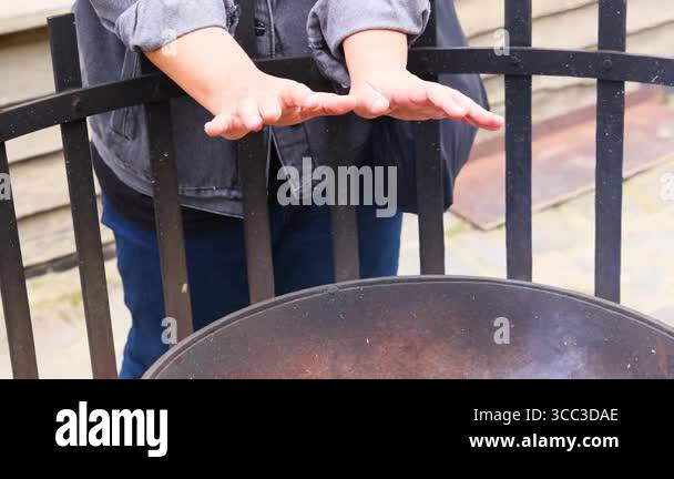 Person warms hands over a fire pit Stock Video Footage - Alamy