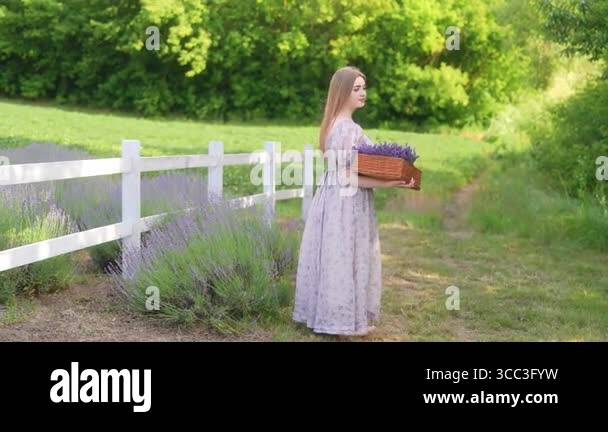 A young woman in a flowing purple dress walking gracefully through a ...