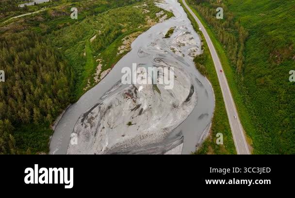 Flying above the dried up delta of the river. Few cars move by the ...