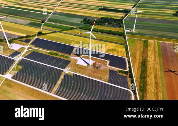 Wind and solar energy scene. Wind turbines tower over expansive solar ...
