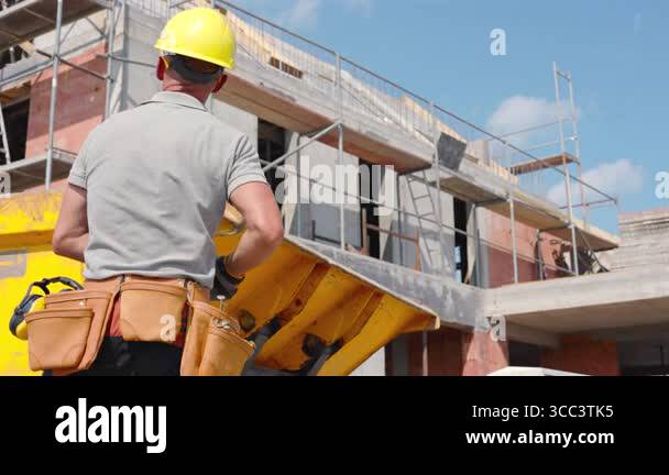 A construction worker operates a loader while collaborating with a team ...
