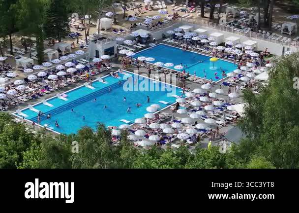 Aerial view of crowded resort with multiple pools, sun loungers, and ...