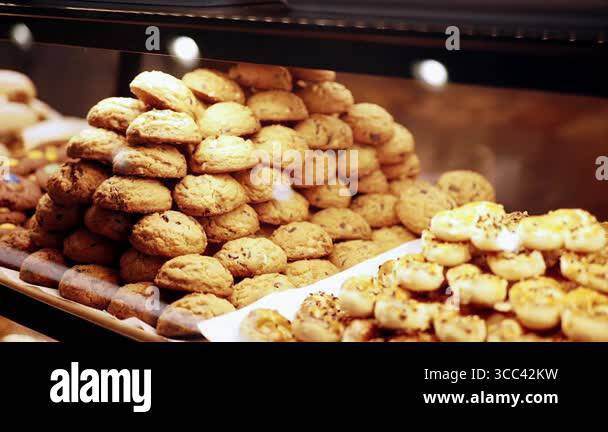 Delicious cookies piled high in a bakery display case tempt customers ...