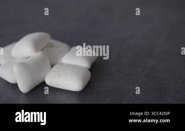 Chewing gum pieces arranged on a dark surface, showcasing texture and ...