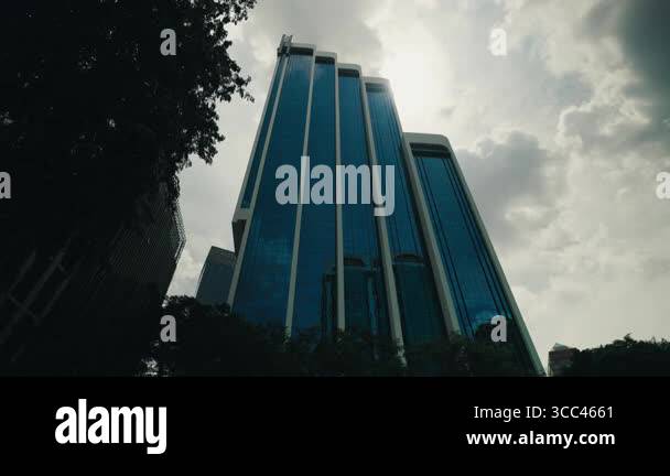 Upward view of modern high-rise building with reflective blue glass ...
