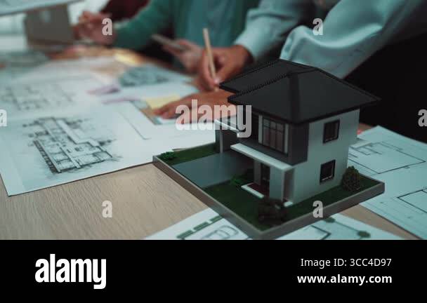 A diverse team collaborates on architectural plans and discusses ...