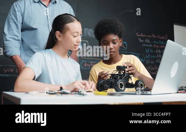 Caucasian teacher pointing at laptop screen while explain car model ...