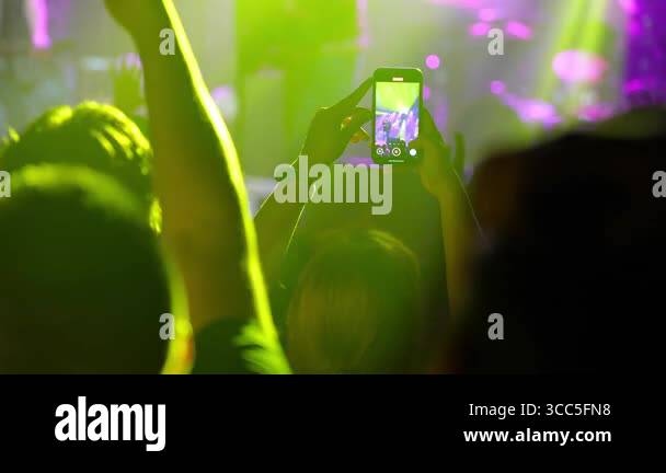 Audience member holds smartphone to capture live performance ...